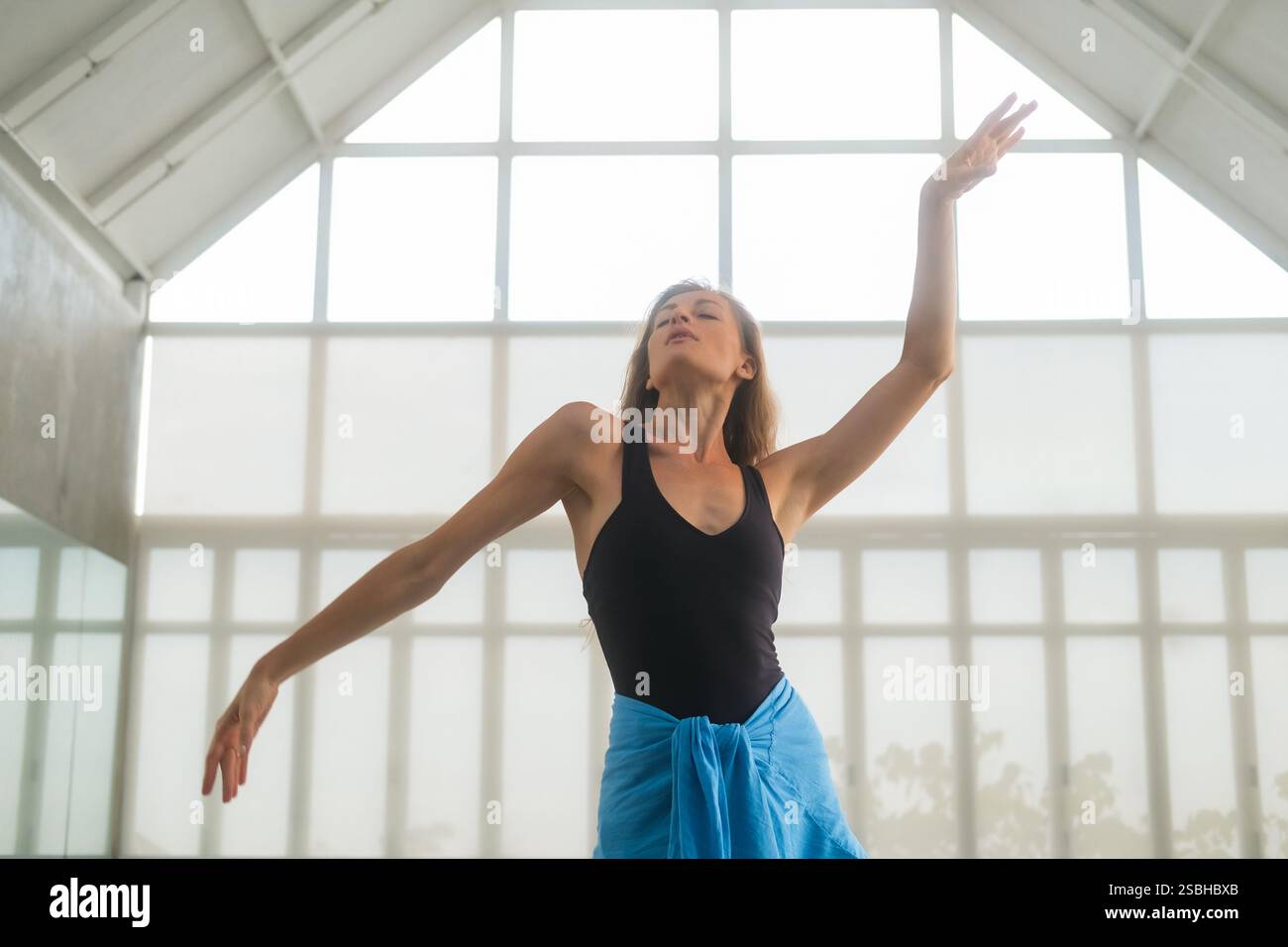 A close-up portrait of a woman gracefully moving her arms and head ...