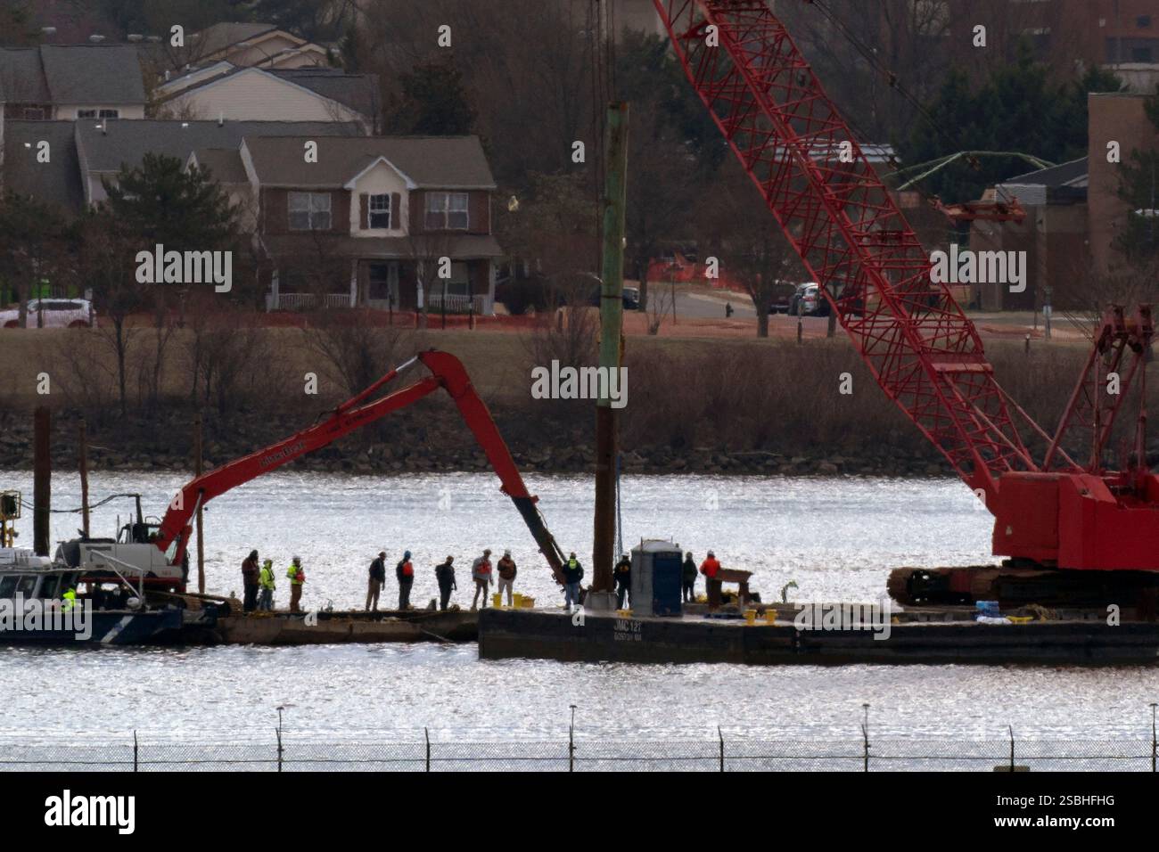 Rescue and salvage crews with cranes work to pull up the wreckage of an American Airlines jet in ...