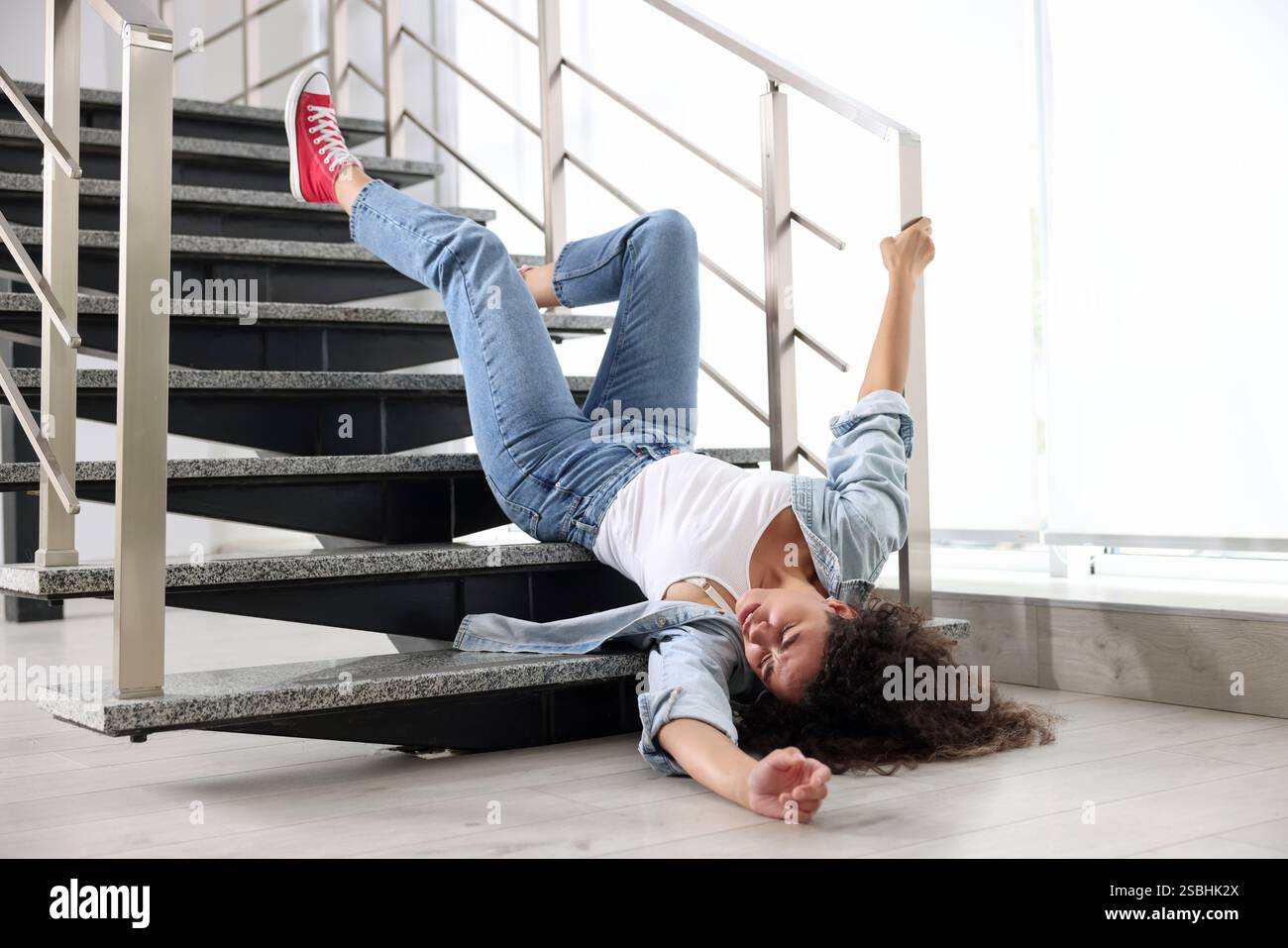 Injured woman on stairs in building after fall. Dangerous accident ...