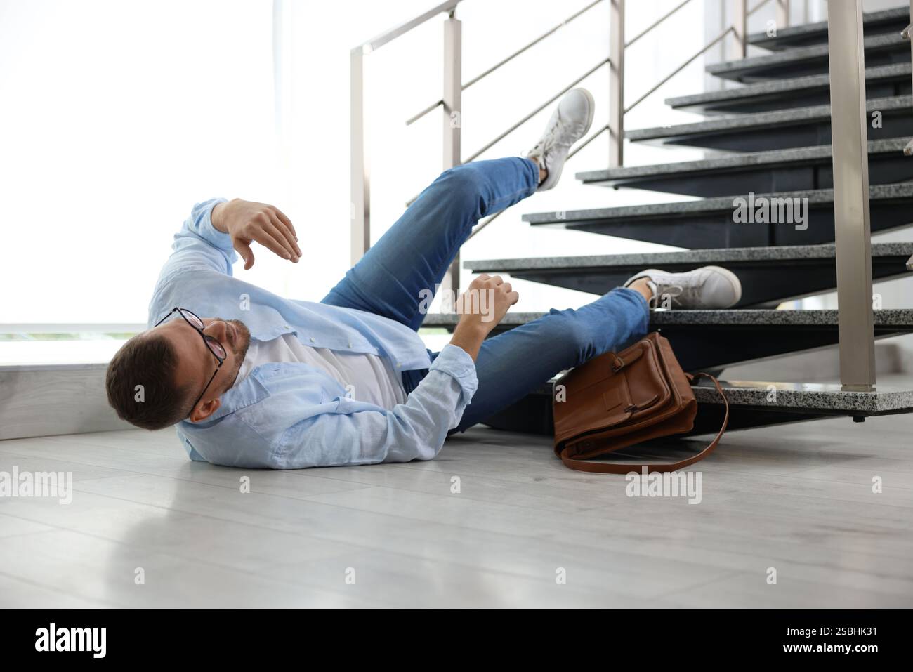 Injured man on floor in building after fall from stairs. Dangerous ...