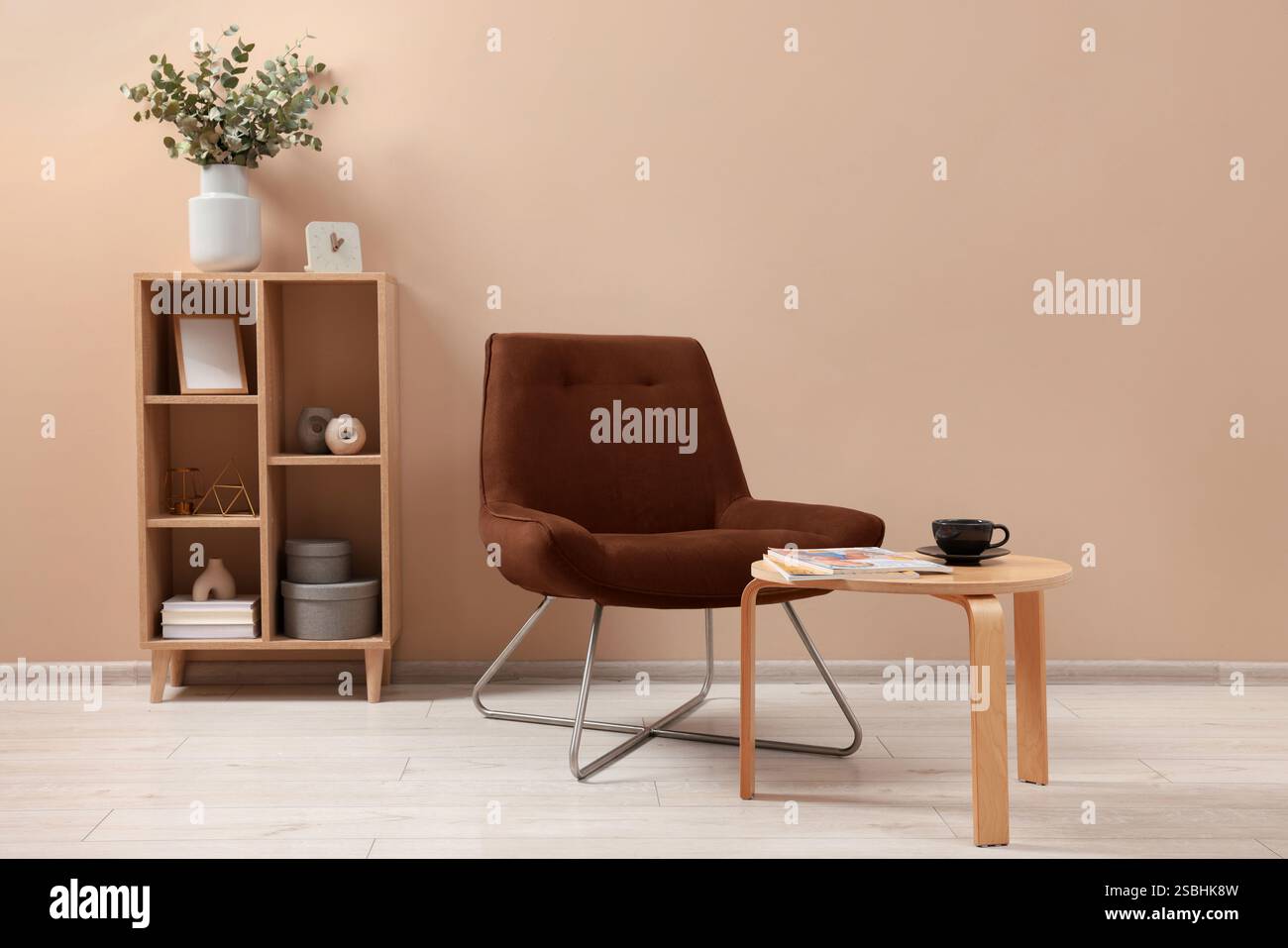 Armchair in mocha mousse shade, table and shelving unit indoors. Cozy ...