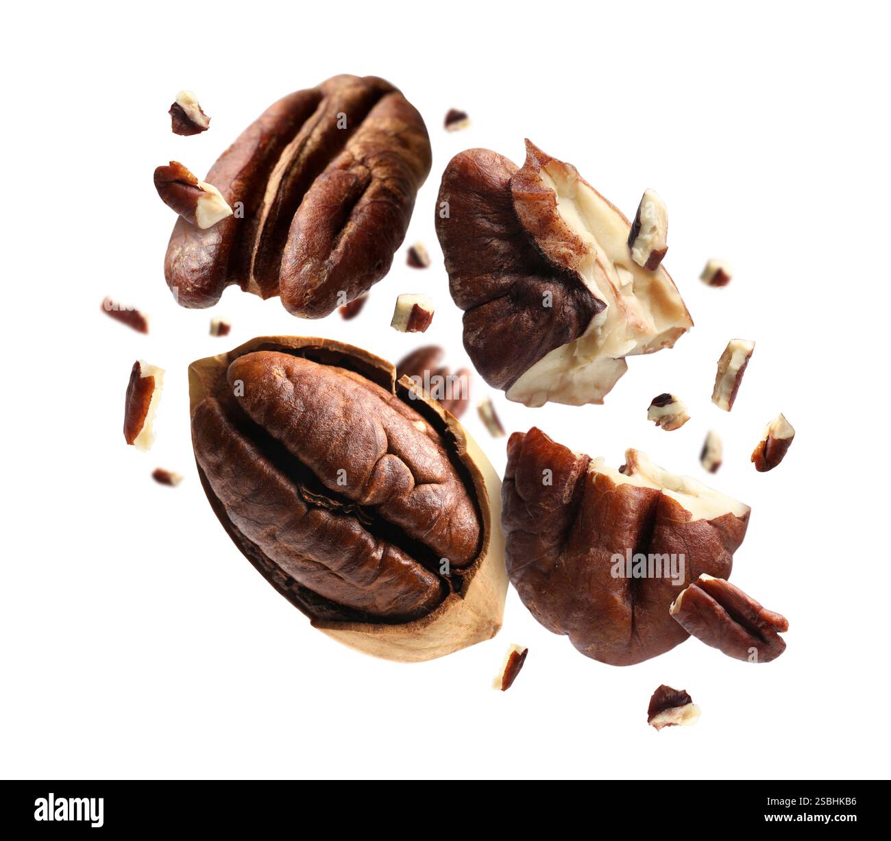 Broken pecan nuts in air on white background Stock Photo - Alamy