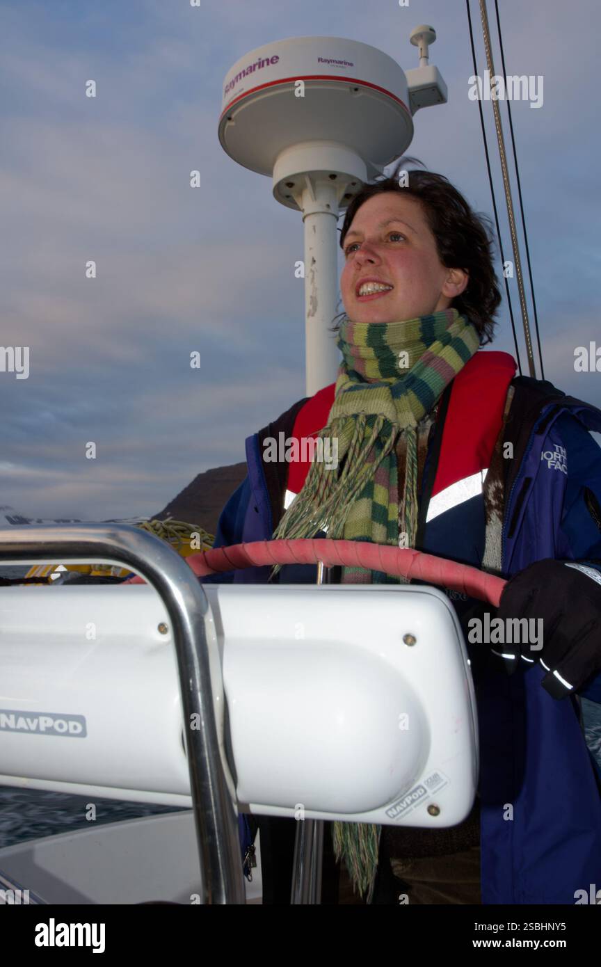 Young woman at the helm of the sailing yacht Aurora at night, West ...