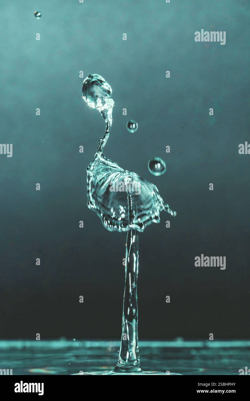 drop of water falling on a water surface and forming abstract shapes ...