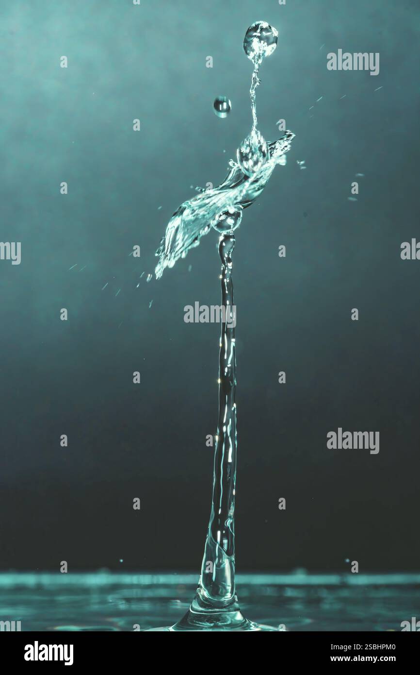 drop of water falling on a water surface and forming abstract shapes ...