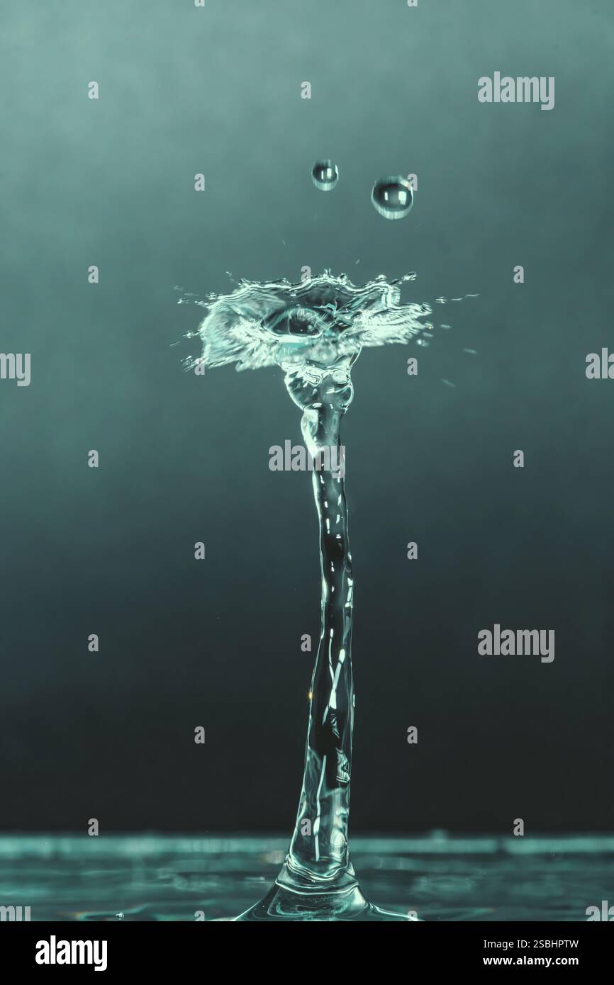 drop of water falling on a water surface and forming abstract shapes ...