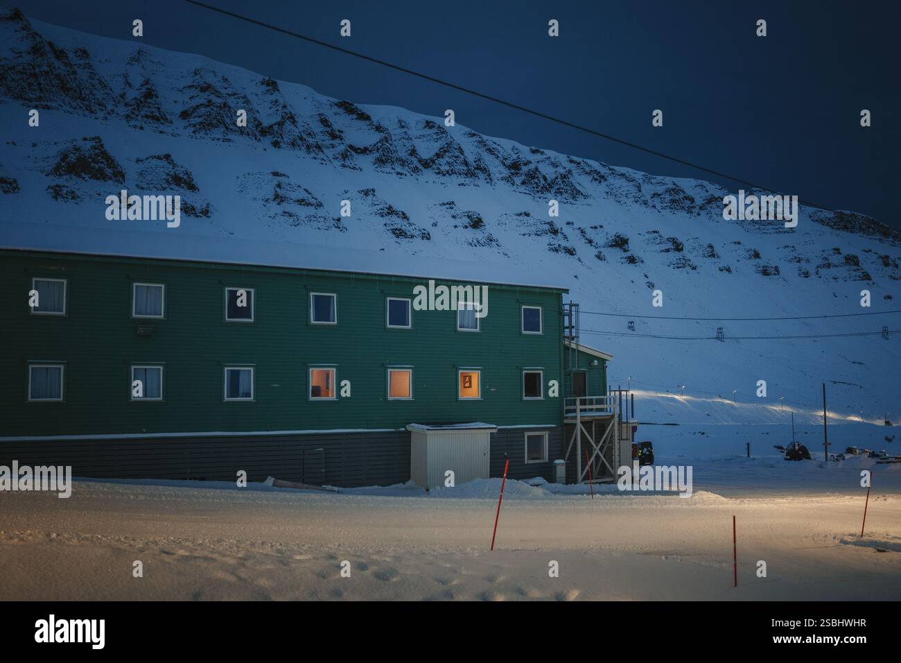 Green building in front of snowy arctic mountains in Longyearbyen ...