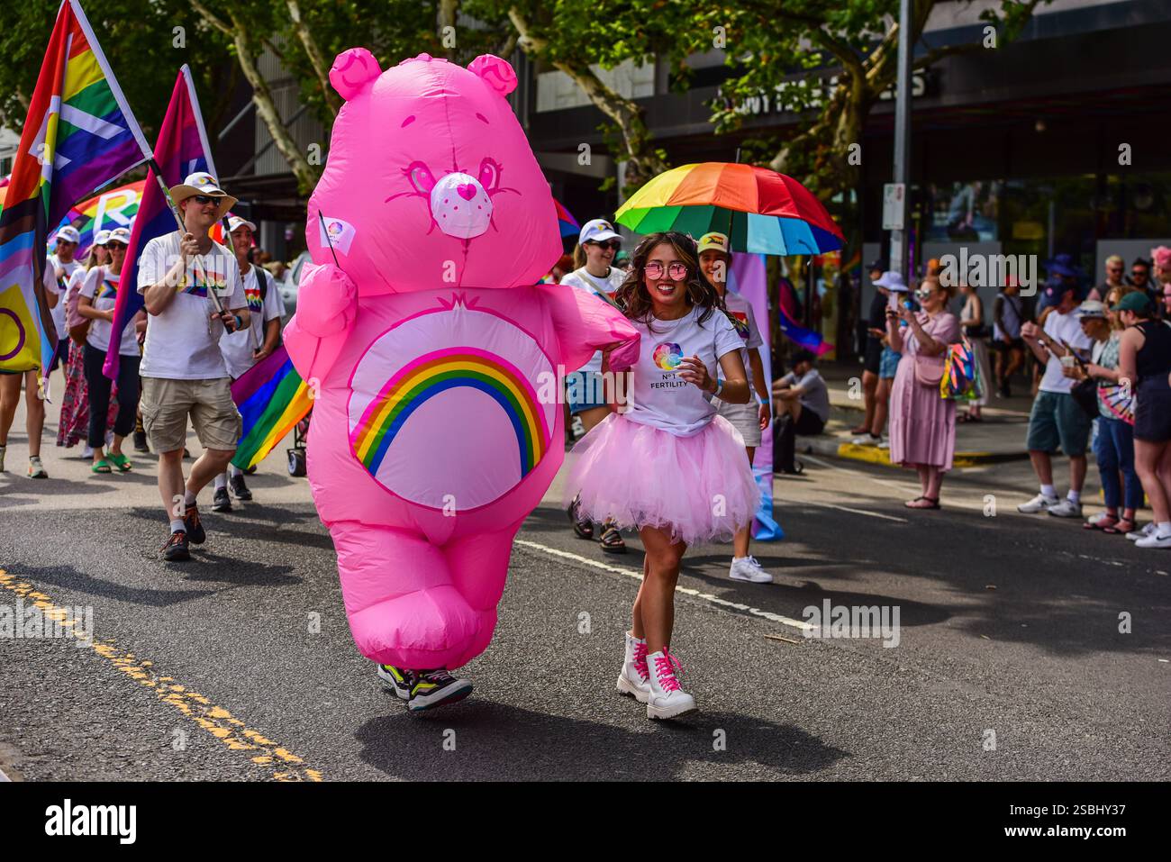 A participant in a Care Bear suit is seen marching in the Pride parade ...
