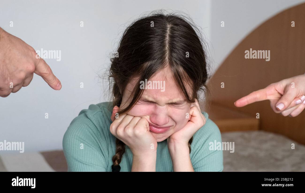 Child girl crying with resentment. Parents scolding her at home. Family ...