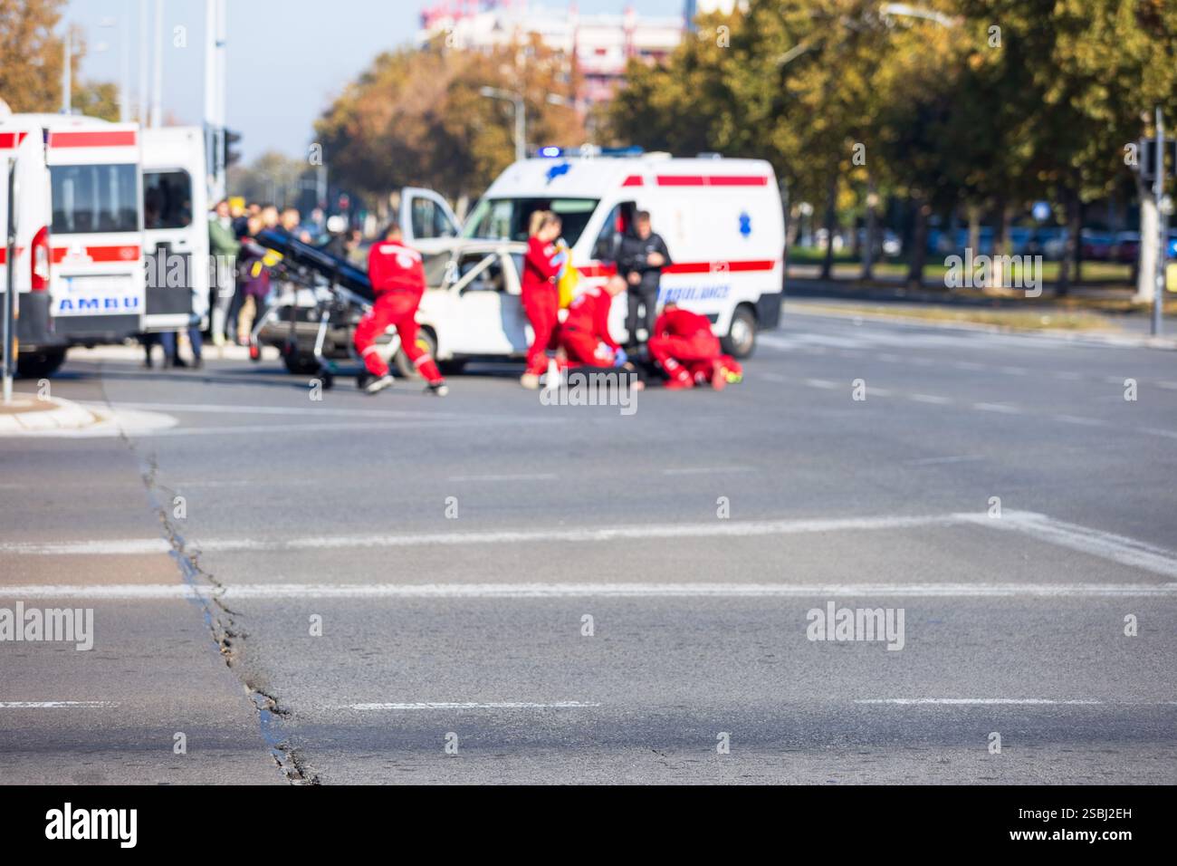 Emergency medical team assisting accident victim on urban road after ...