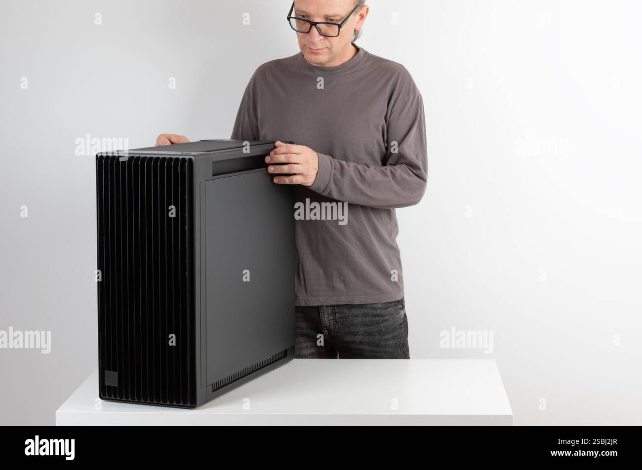 Man putting to table heavy PC case, weight 15,8 kg, empty big tower ...