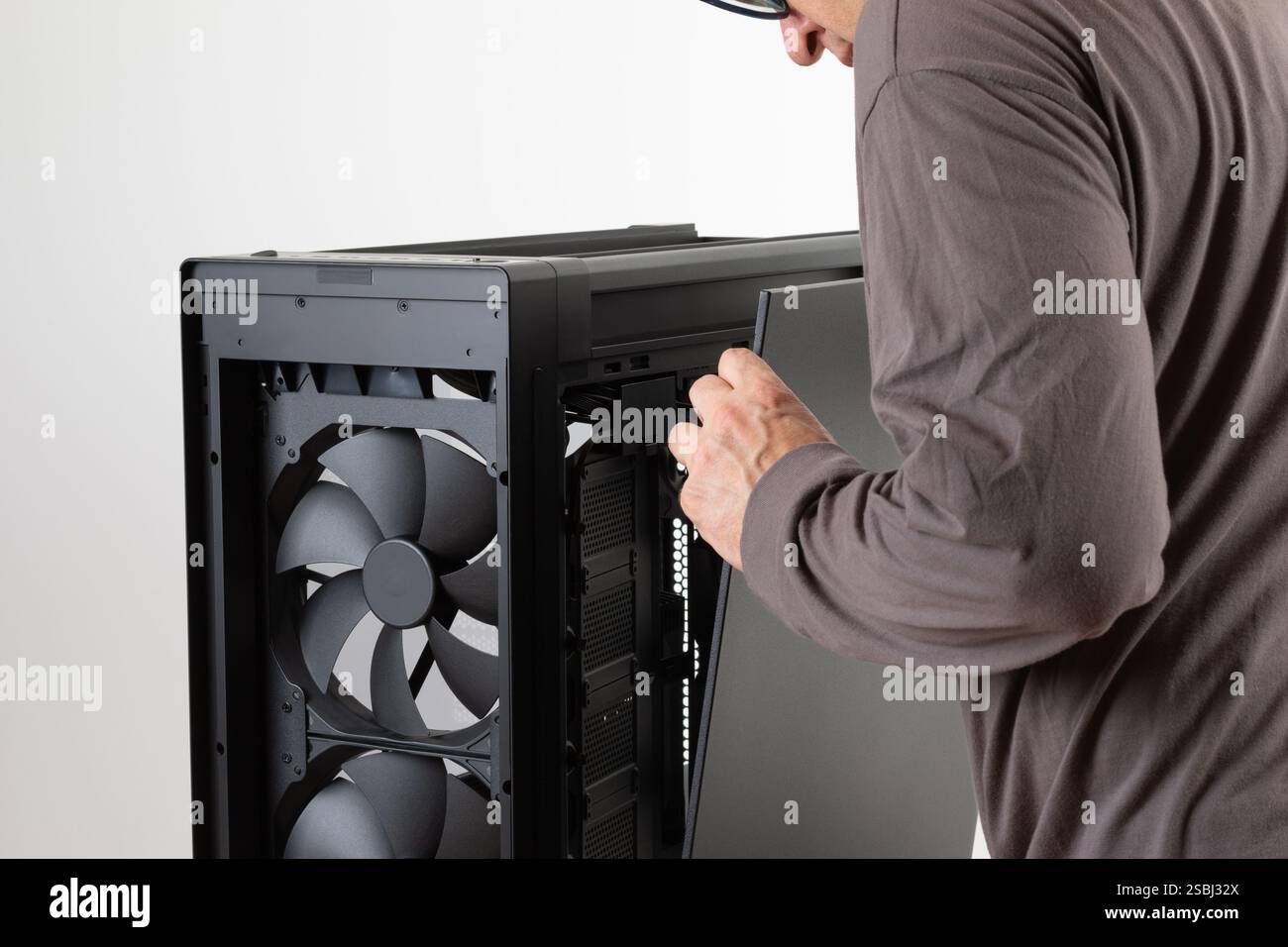 Man removing metal right panel from PC case, empty big tower, chassis ...