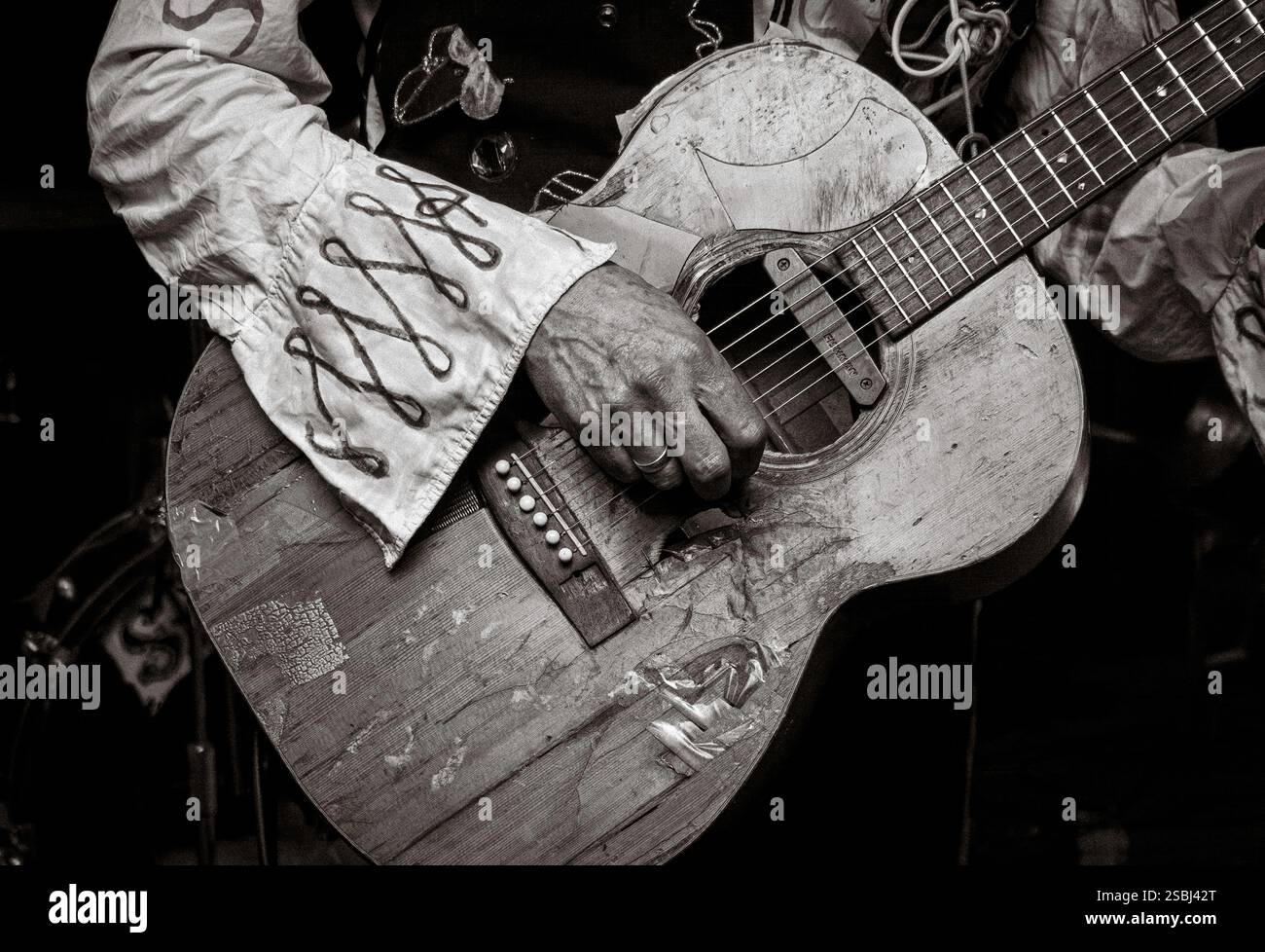 Person playing an old beat up acoustic guitar Stock Photo - Alamy