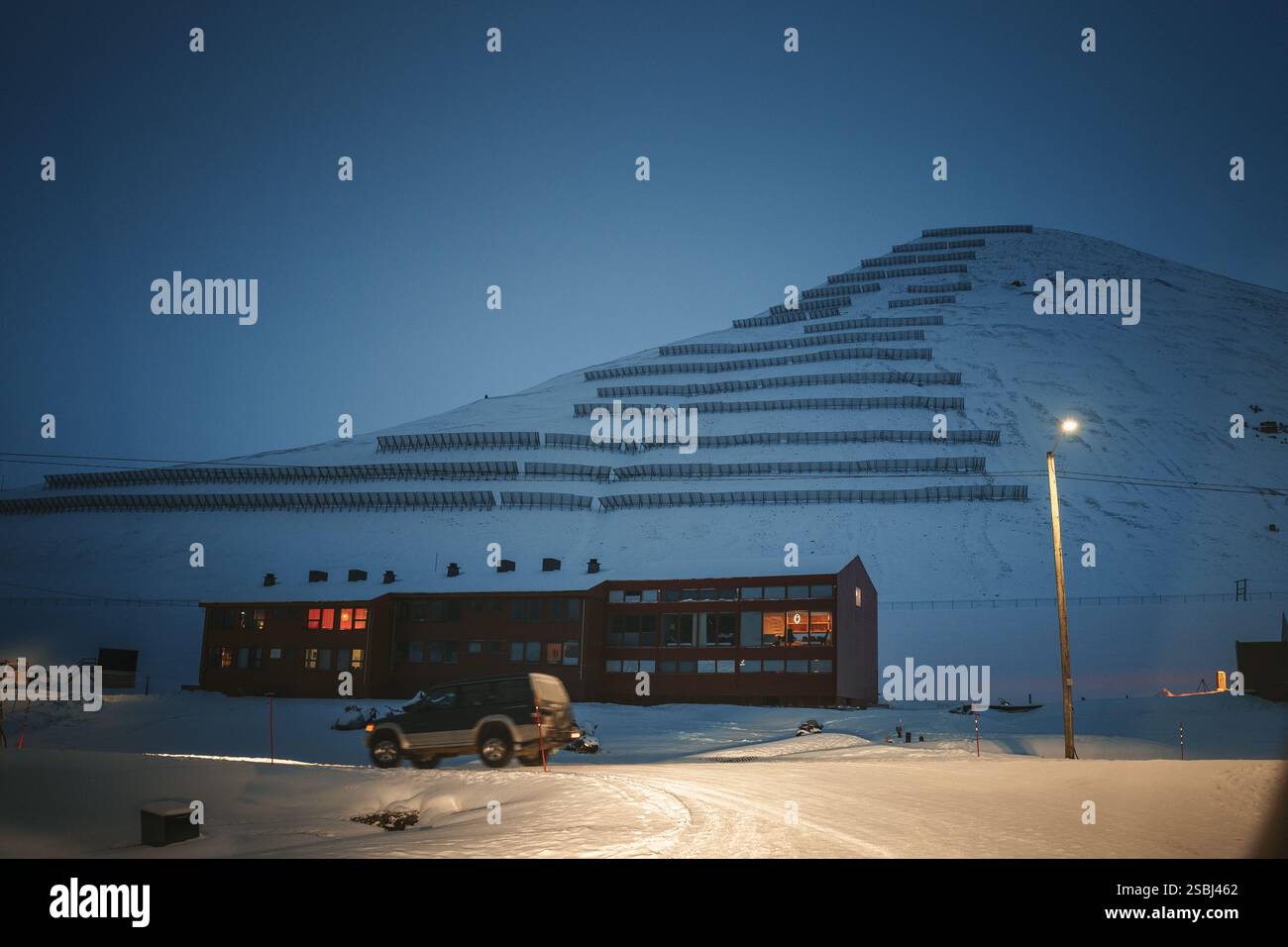 Snowy mountain behind building in the arctic in Longyearbyen, Svalbard ...