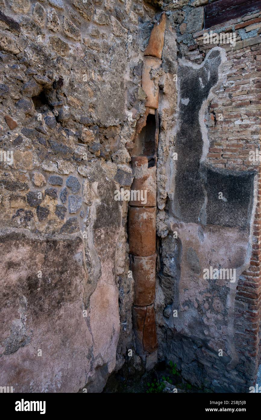 A broken ceramic drain pipe in the wall of Building I.7.8 in the ...