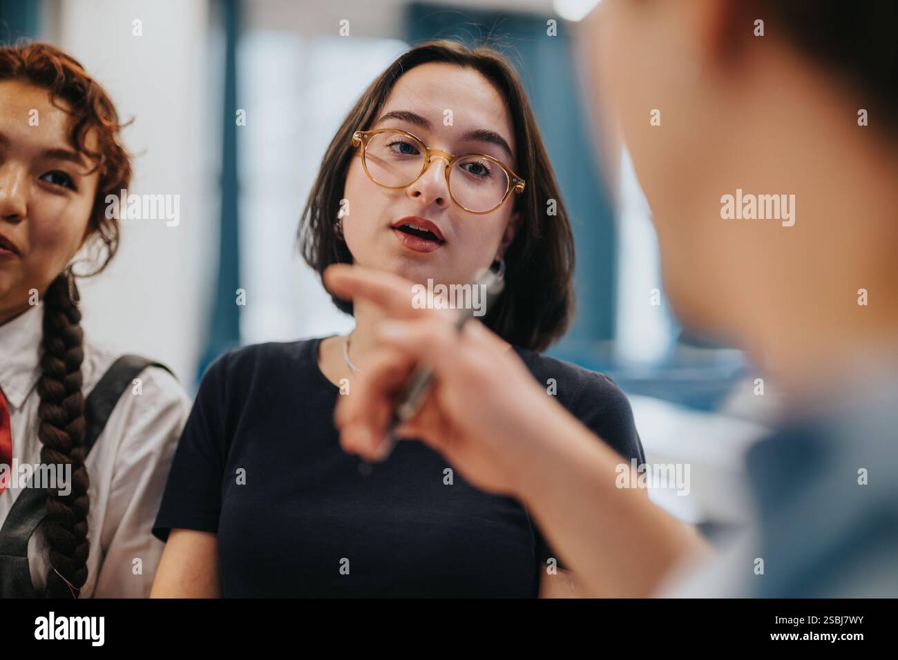 High school students engaged in classroom discussion with teacher Stock ...