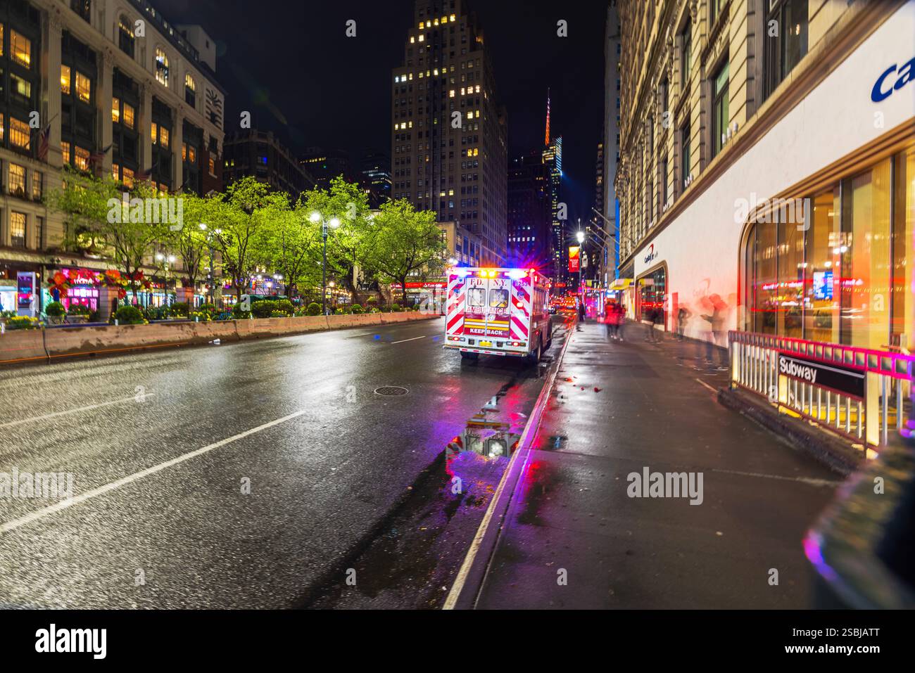 FDNY ambulance with flashing lights on wet Manhattan street at night ...