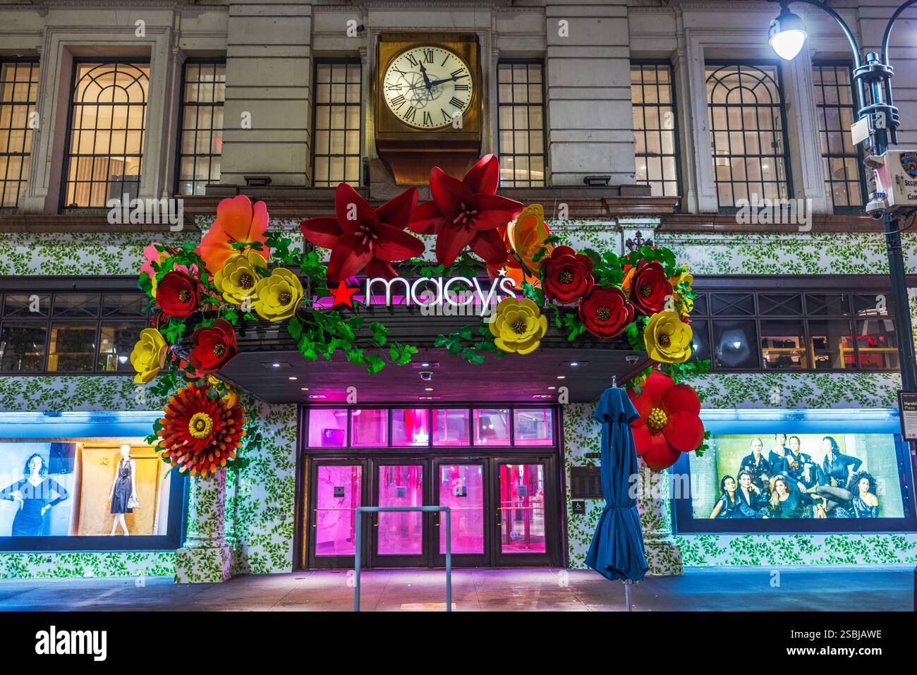 Illuminated Macy’s store entrance with vibrant floral decorations at ...