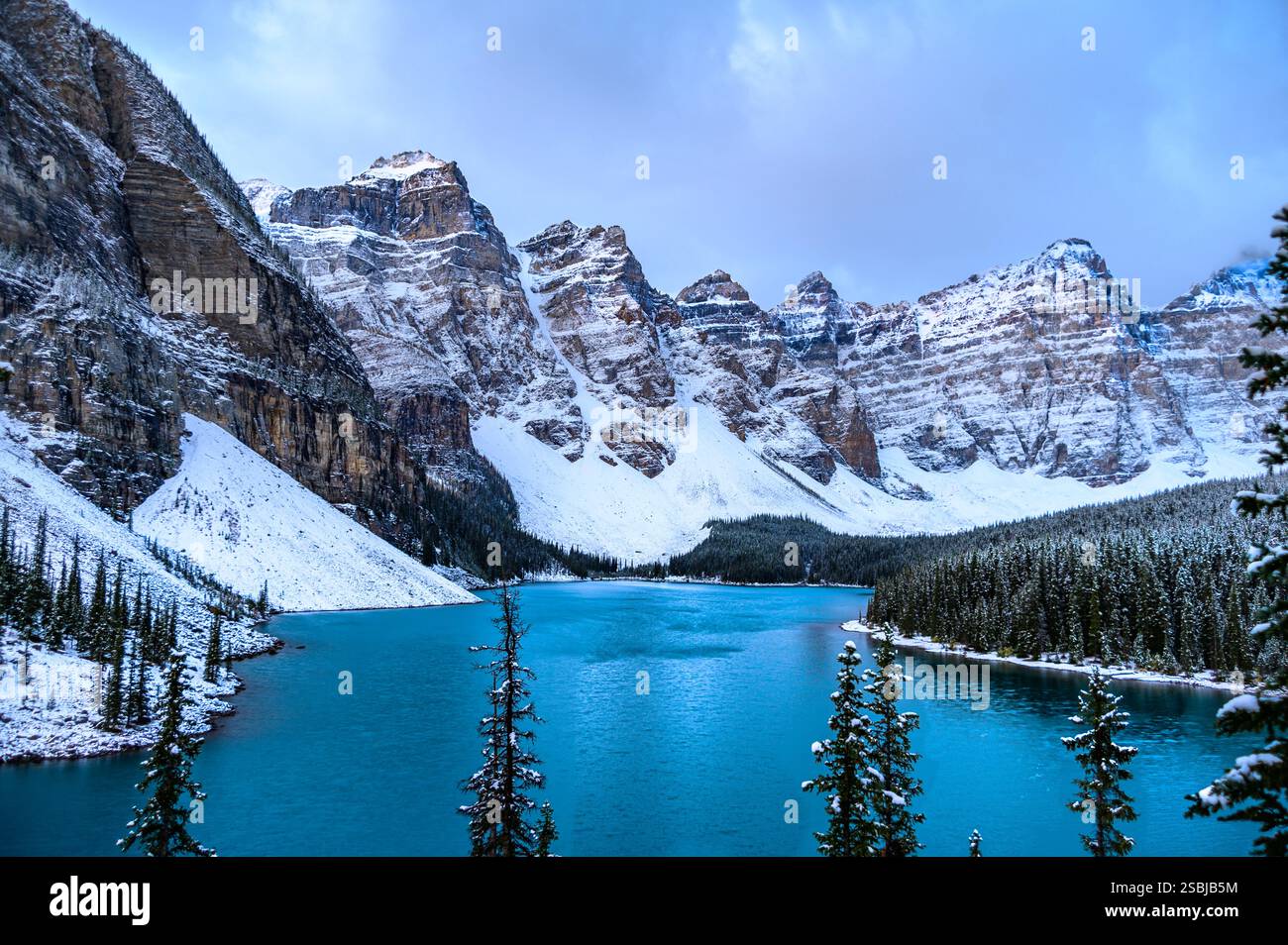 Lake Moraine blue water and ten peak mountains with autumn snow along with pine trees during ...