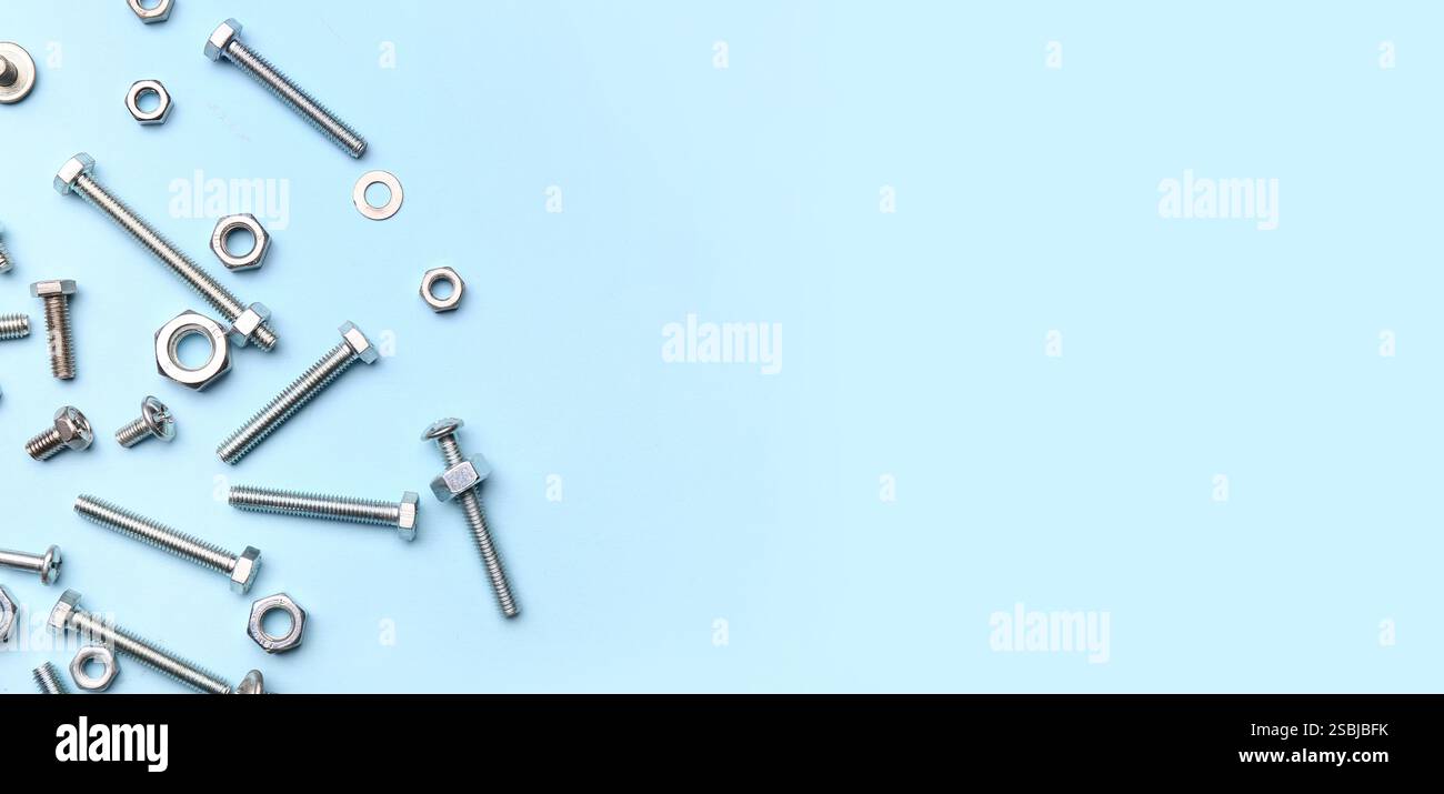 Tap bolts with nuts and washers on light blue background with space for ...
