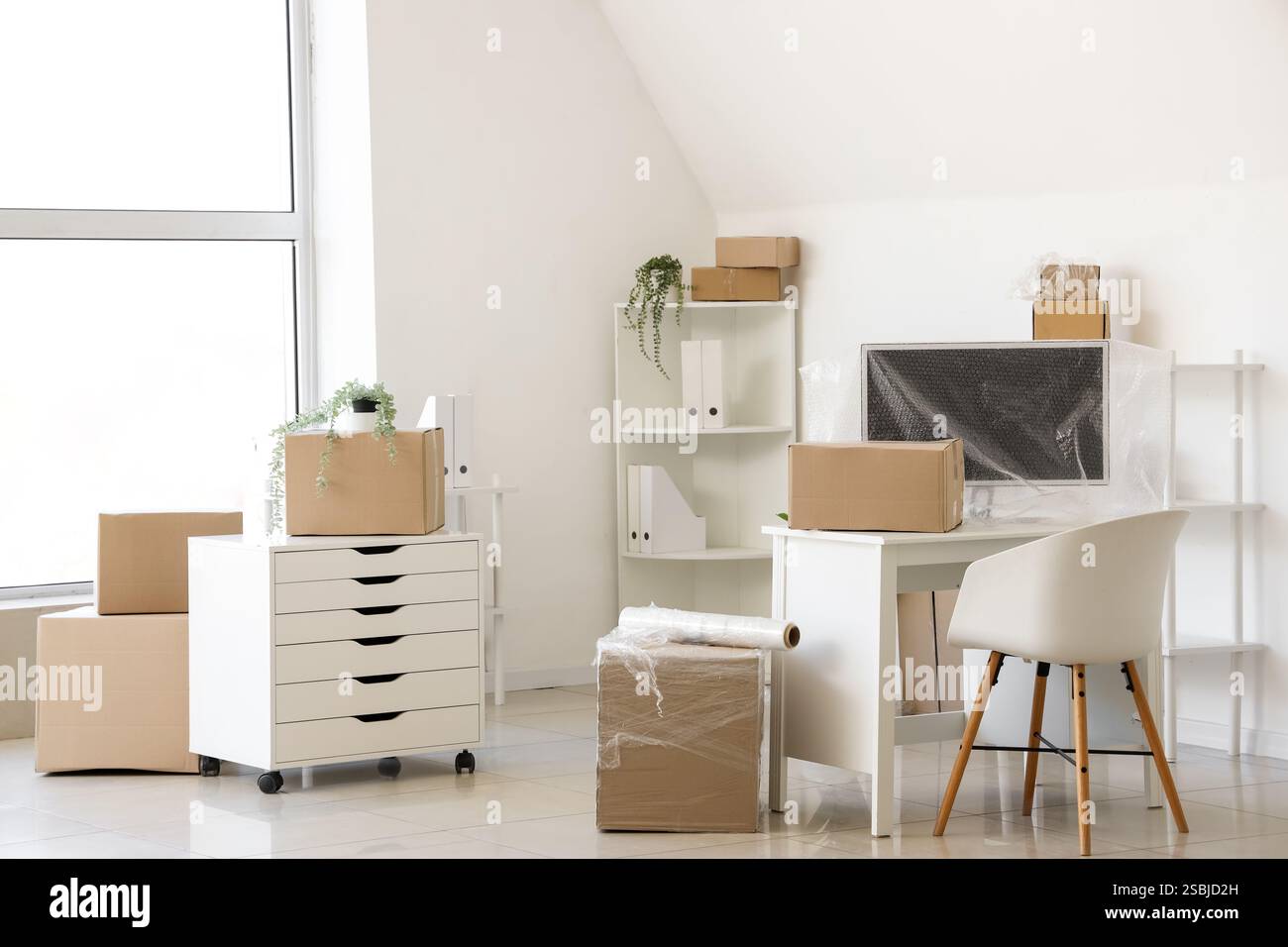 Interior of light office with cardboard boxes and stretch film on ...