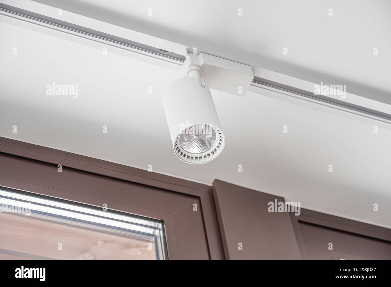 A modern track lighting system with adjustable white spotlights is ...