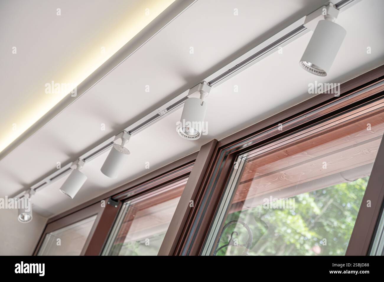 A modern track lighting system with adjustable white spotlights is ...