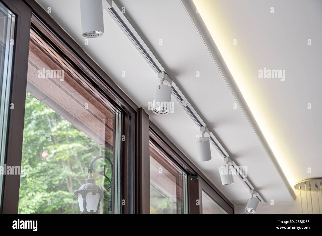 A modern track lighting system with adjustable white spotlights is ...