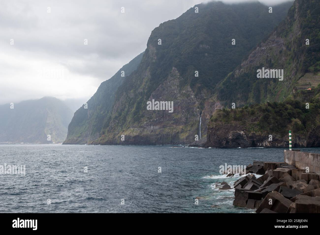 Volcanic rocks and cliffs. Calm dark water of Atlantic ocean during a ...
