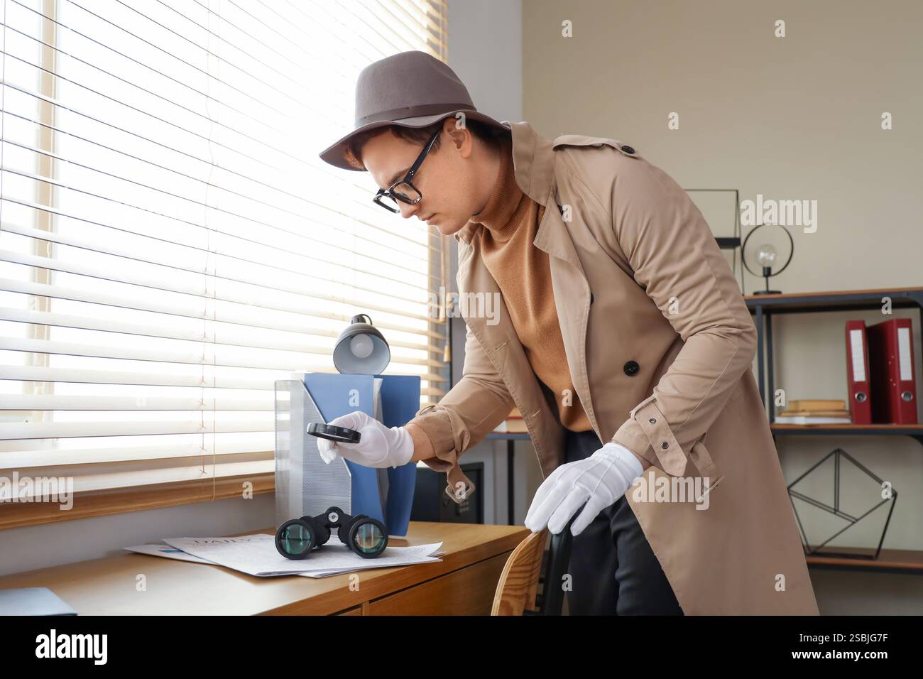 Male spy with magnifier inspecting place in office Stock Photo - Alamy