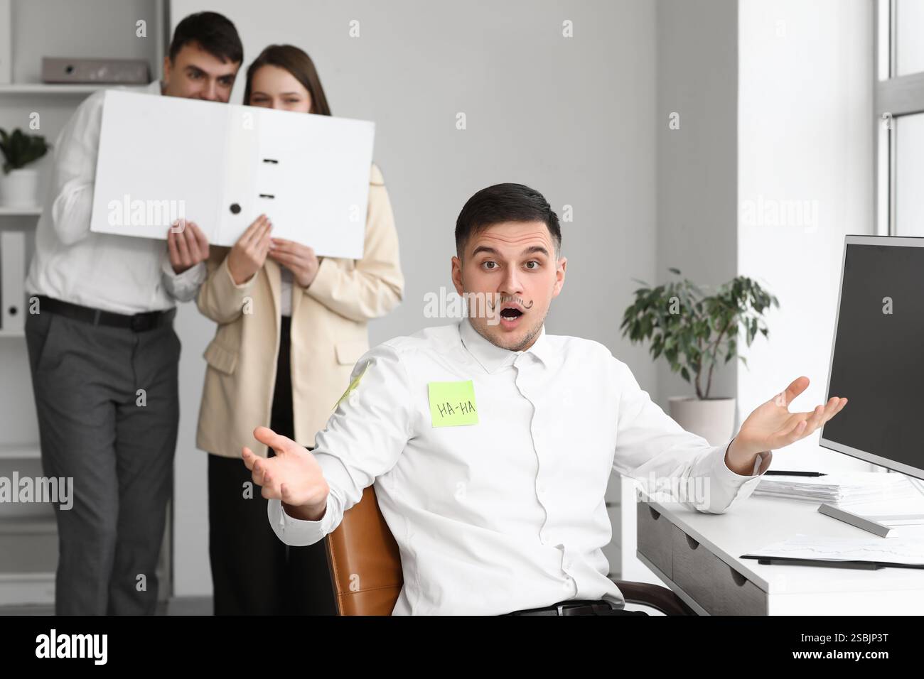 Shocked young man with drawn mustache and his colleagues in office ...