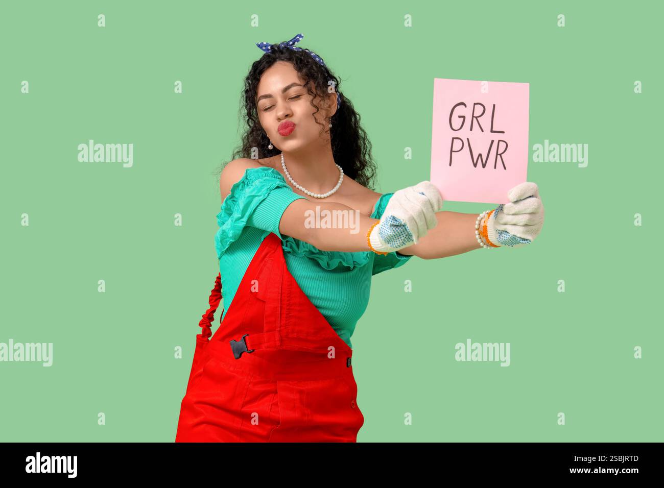 Young African-American pin-up woman with GRL PWR sign on green ...