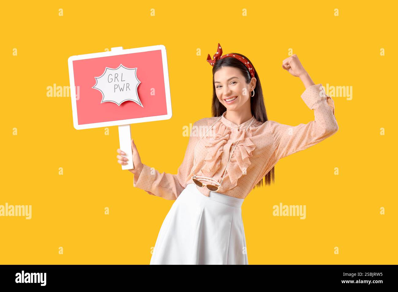 Young pin-up woman with GRL PWR sign showing muscles on yellow ...
