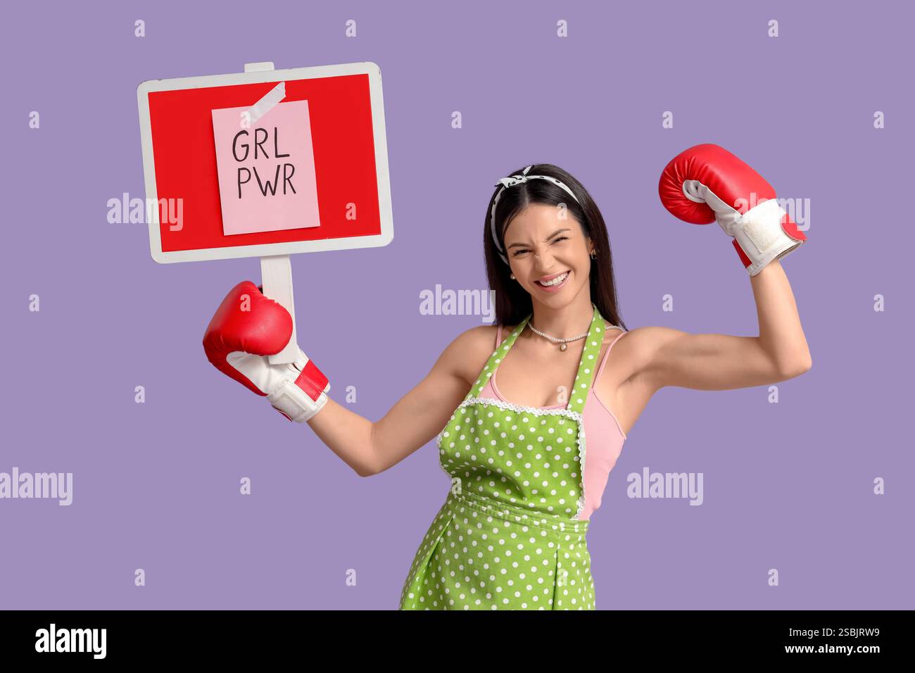 Young pin-up woman in apron with boxing gloves and GRL PWR sign on ...