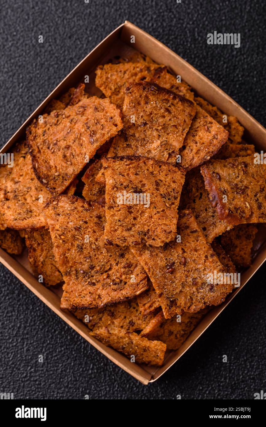 Crispy homemade brown bread chips with seeds and grains, salt, spices ...