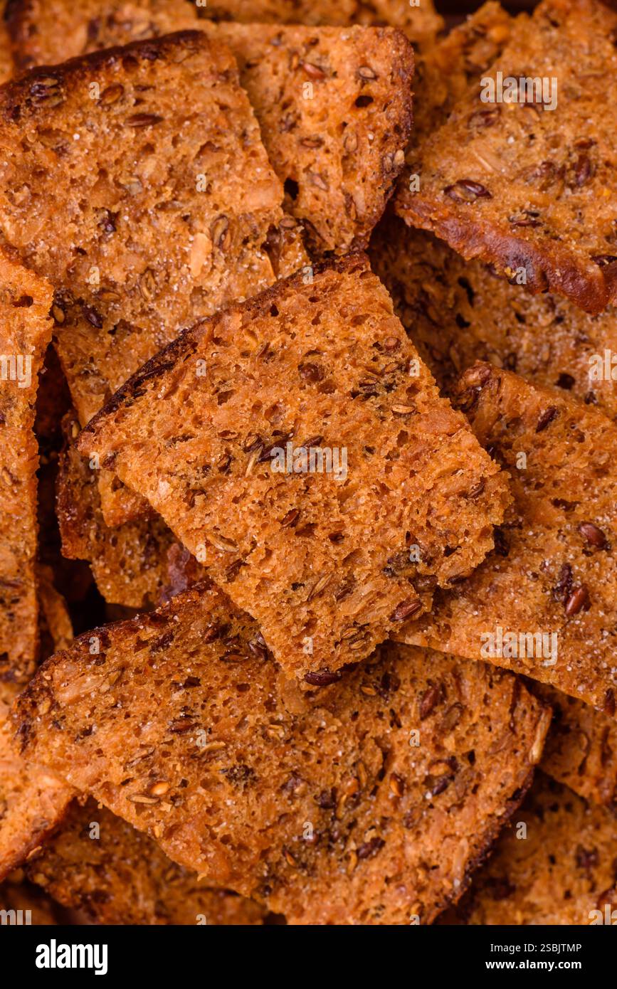 Crispy homemade brown bread chips with seeds and grains, salt, spices ...