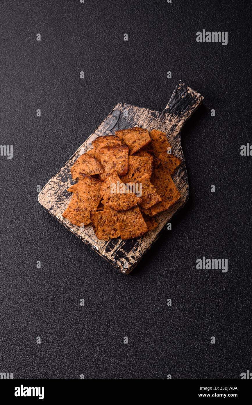 Crispy homemade brown bread chips with seeds and grains, salt, spices ...