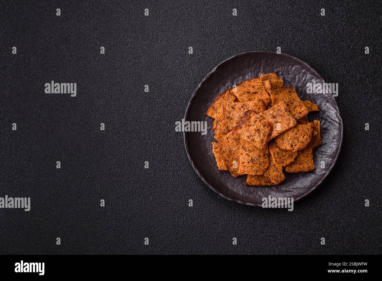 Crispy homemade brown bread chips with seeds and grains, salt, spices ...