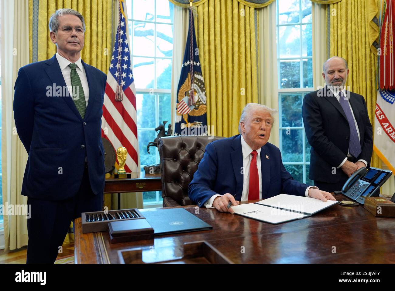 President Donald Trump speaks as Treasury Secretary Scott Bessent, left ...