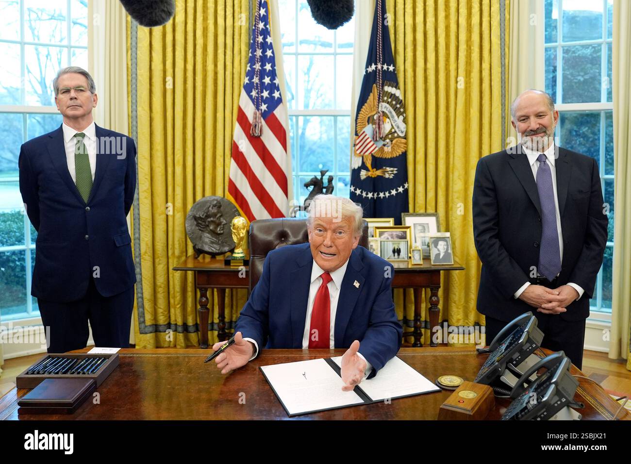 President Donald Trump speaks as Treasury Secretary Scott Bessent, left ...
