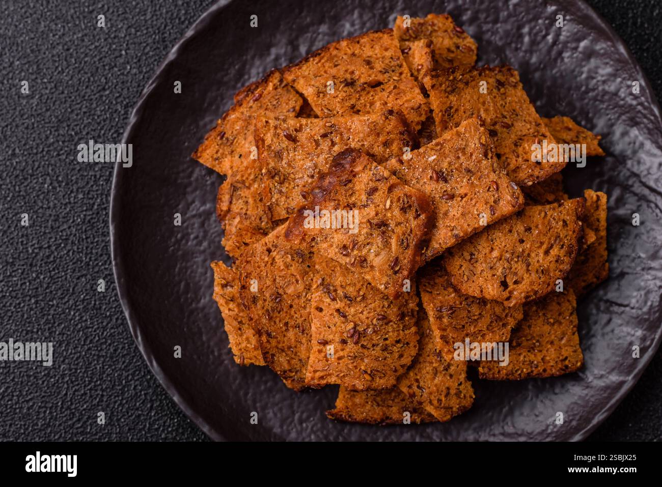 Crispy homemade brown bread chips with seeds and grains, salt, spices ...