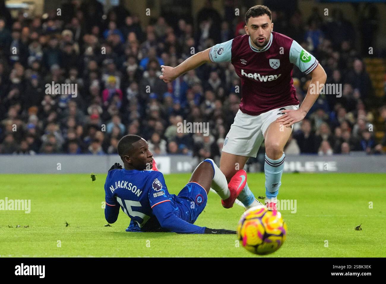 Chelsea's Nicolas Jackson, bottom, and West Ham's Max Kilman challenge ...