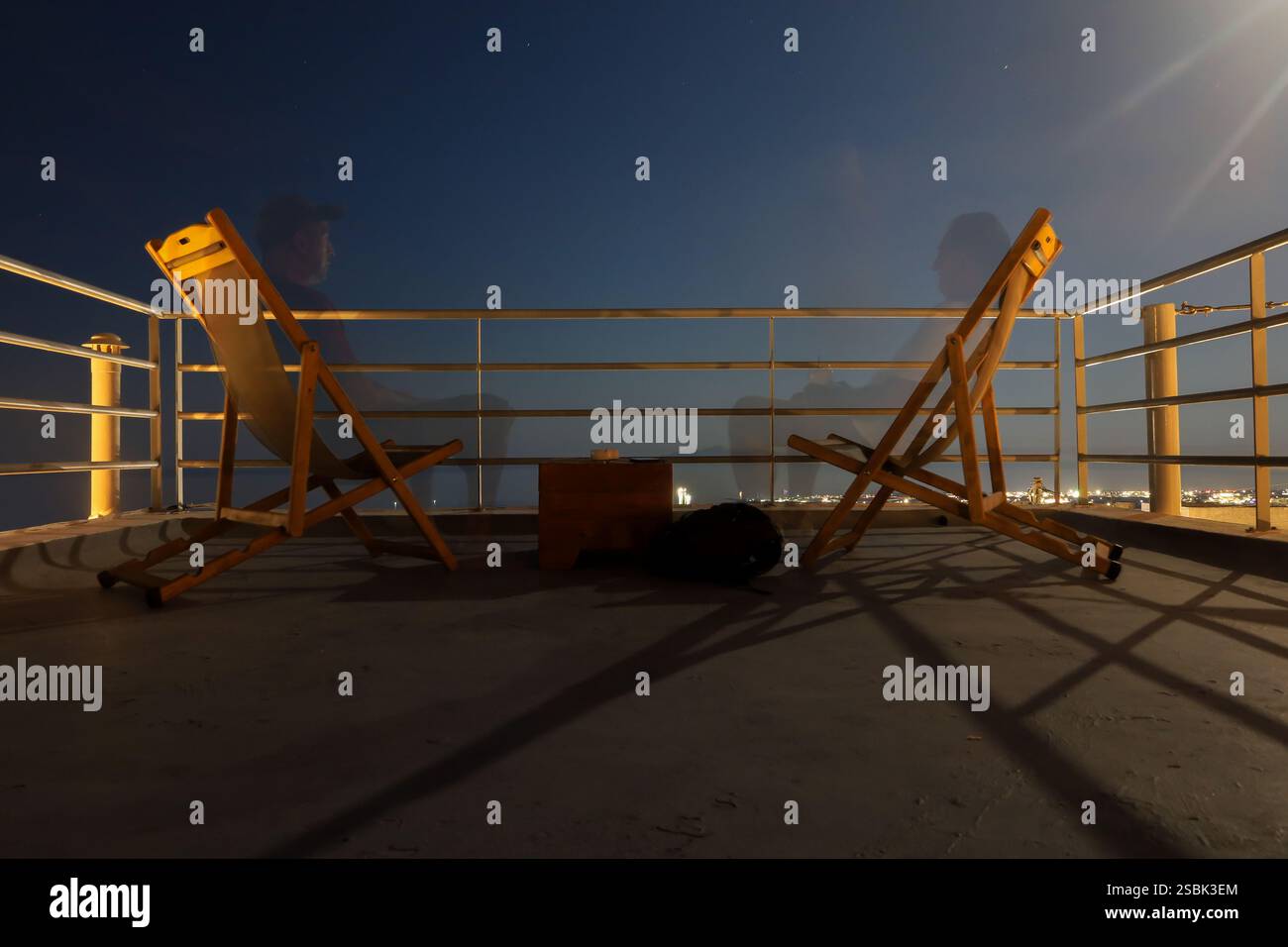 long-exposure at night image of two people are sitting in a wooden ...