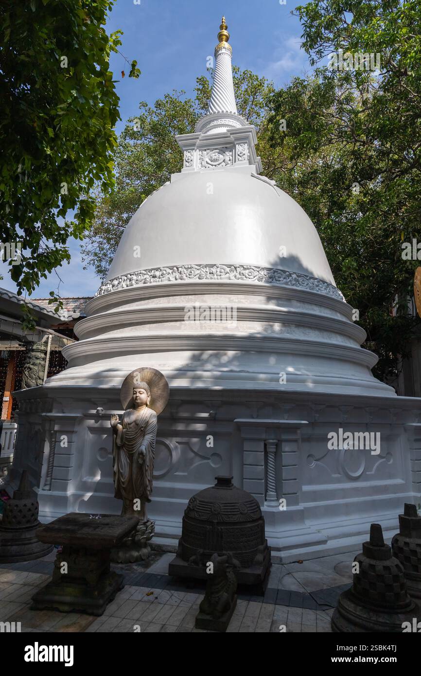Buddha statue placed in front of white pagoda of Gangaramaya Temple ...