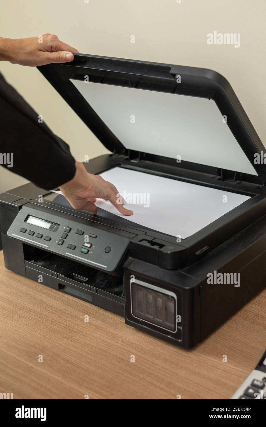 A professional woman scanning documents using an office scanner in a ...