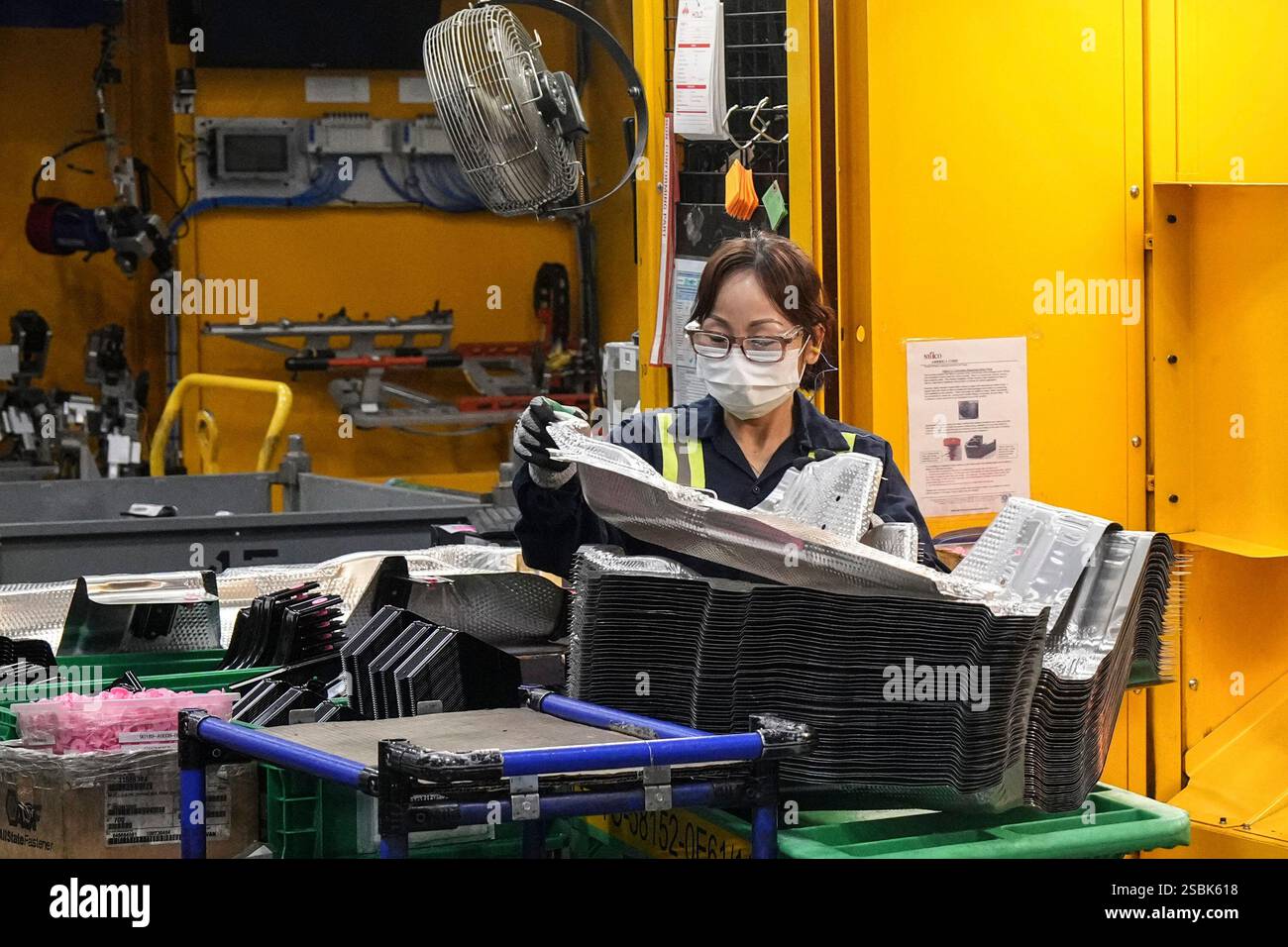 An employee works on the production line at the Martinrea auto parts ...