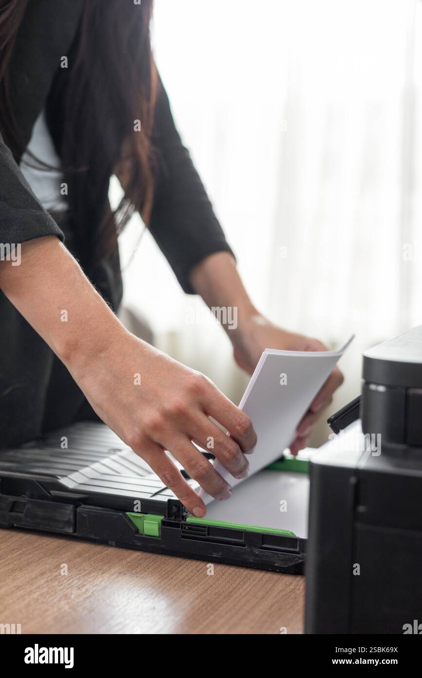 A professional loading paper into an office printer, showcasing ...