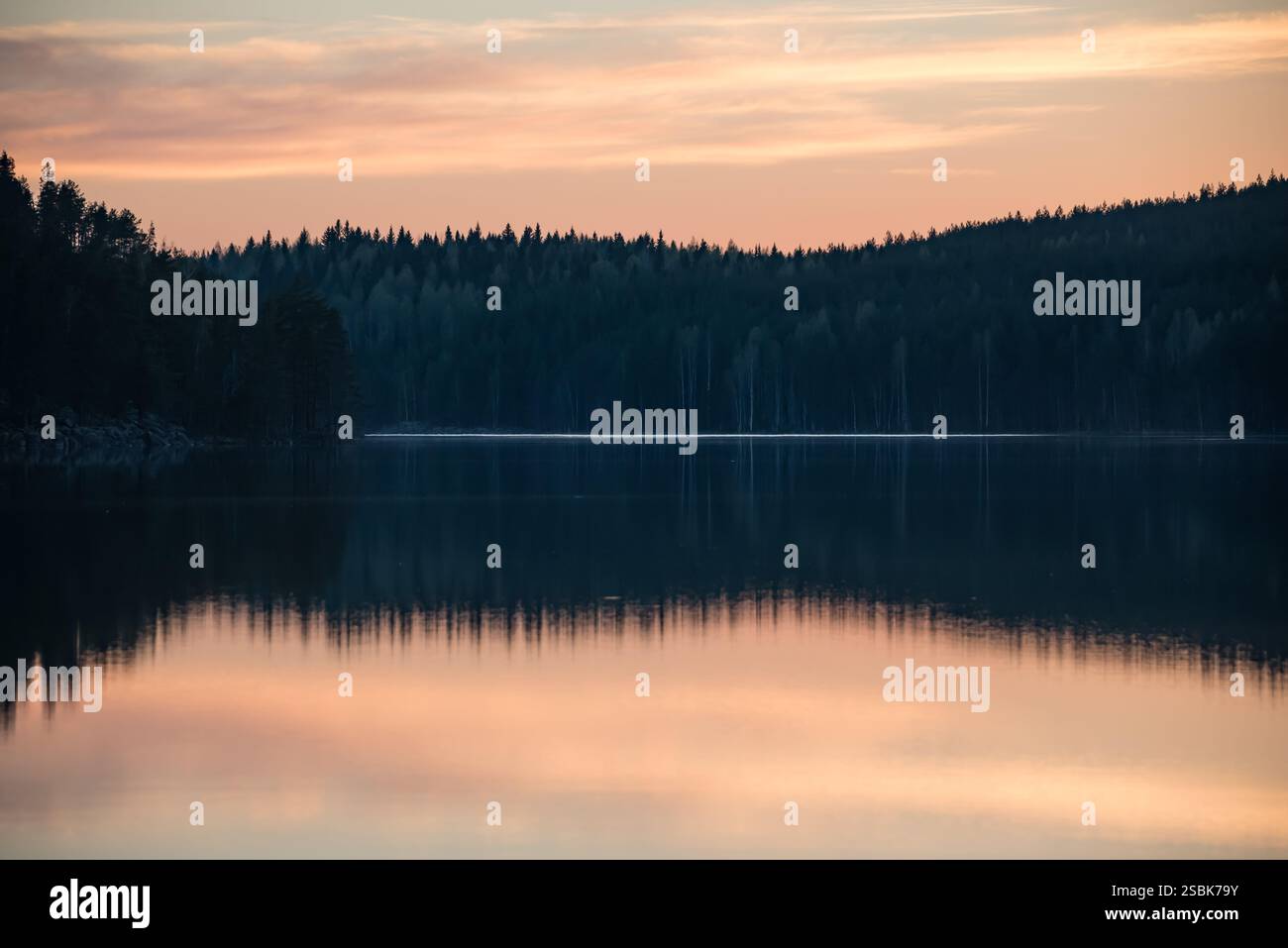 Lake scenery around sunset on a late spring evening in conifer forests ...