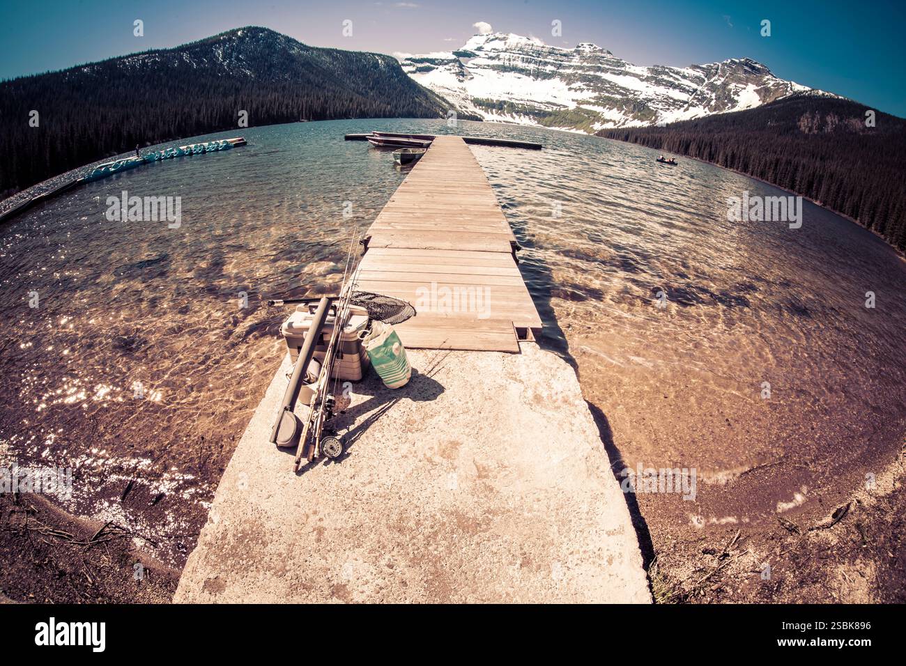 Dock is in the water with a boat tied to it. A camera is on the dock ...