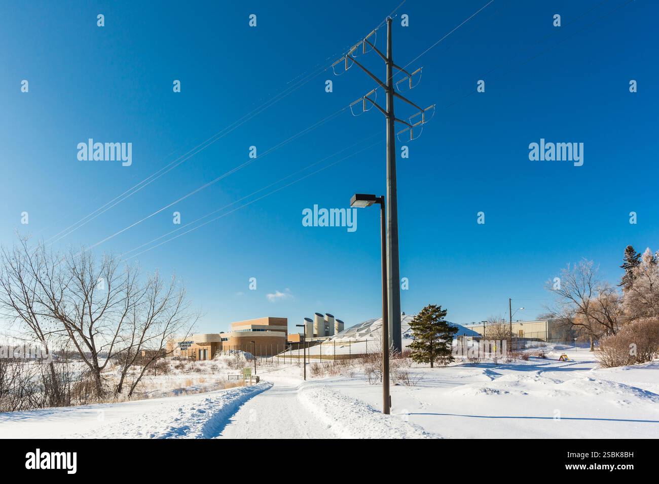 A pole with a light on top of it. The pole is in the snow. The sky is ...
